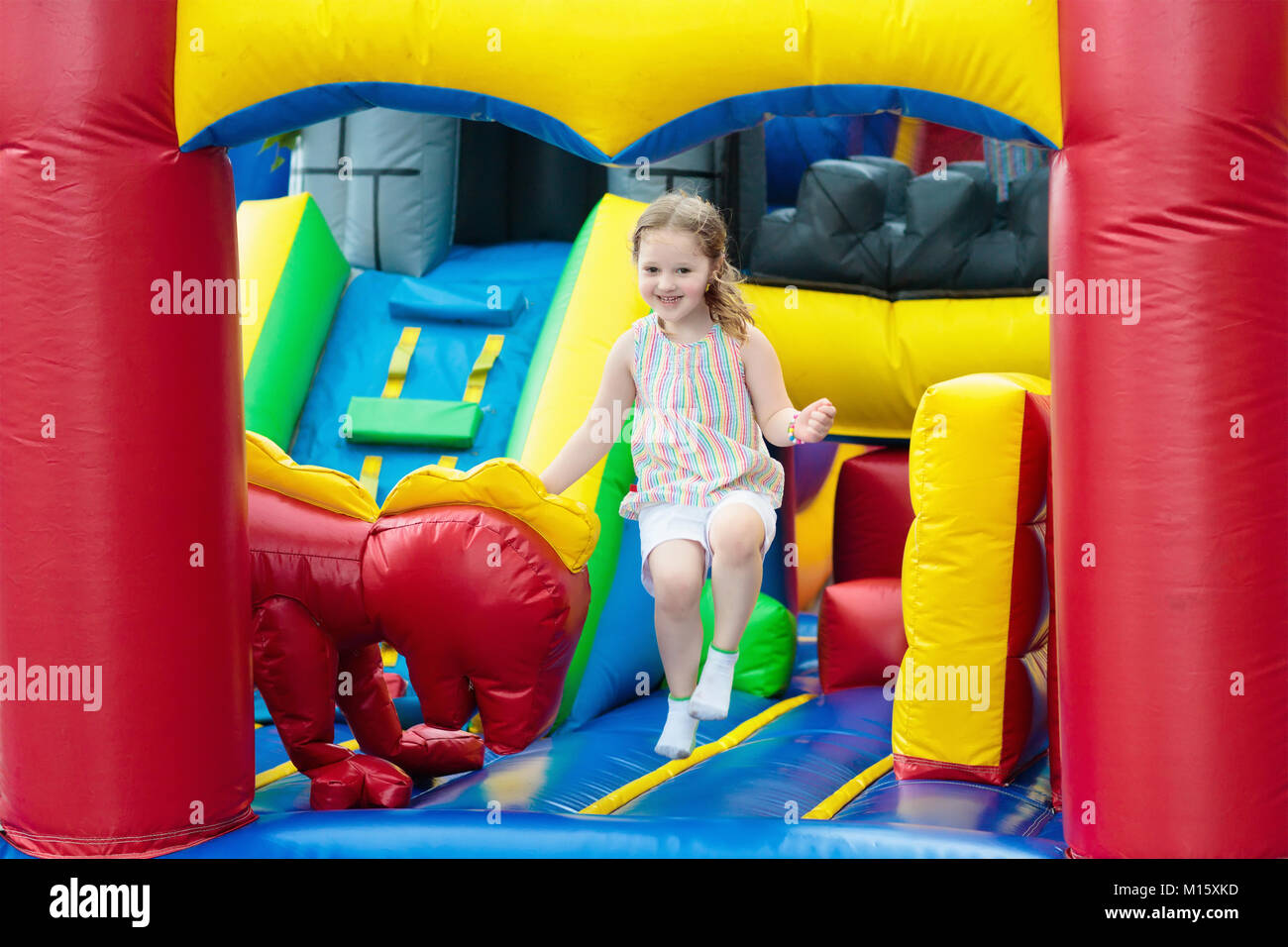 Child jumping on colorful playground trampoline. Kids jump in ...
