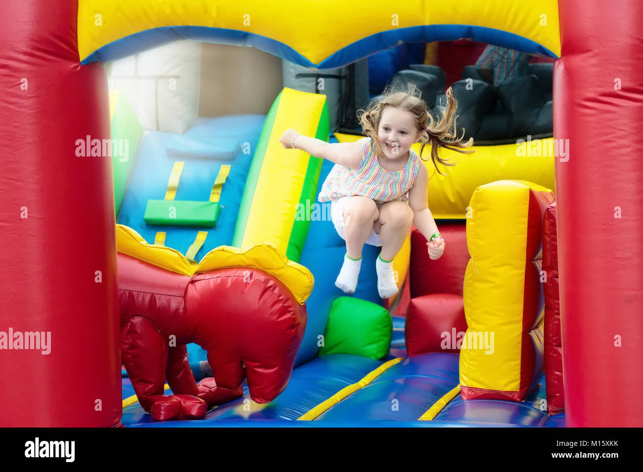 Child jumping on colorful playground trampoline. Kids jump in ...