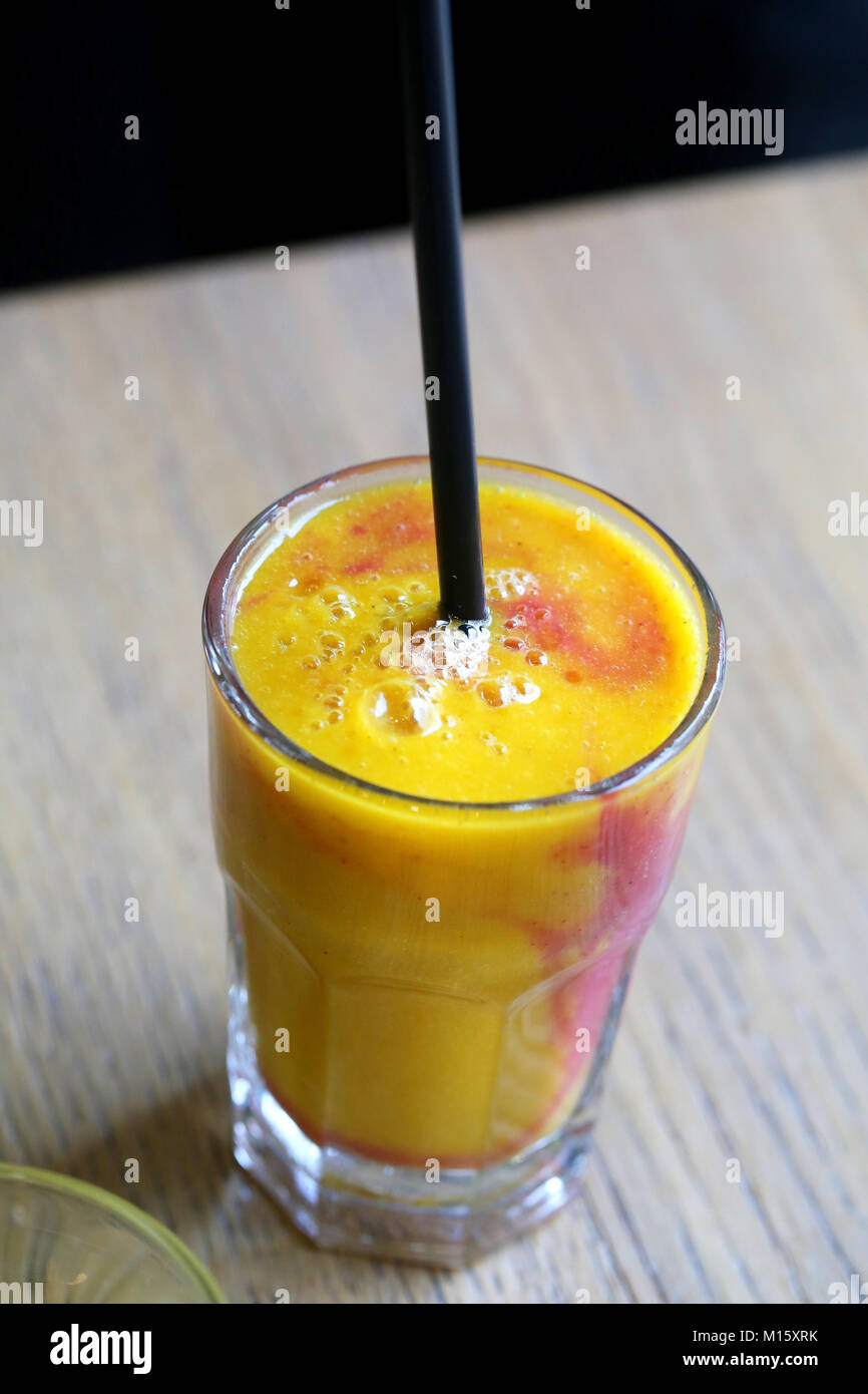 fruit juice in a glass with a straw Stock Photo - Alamy