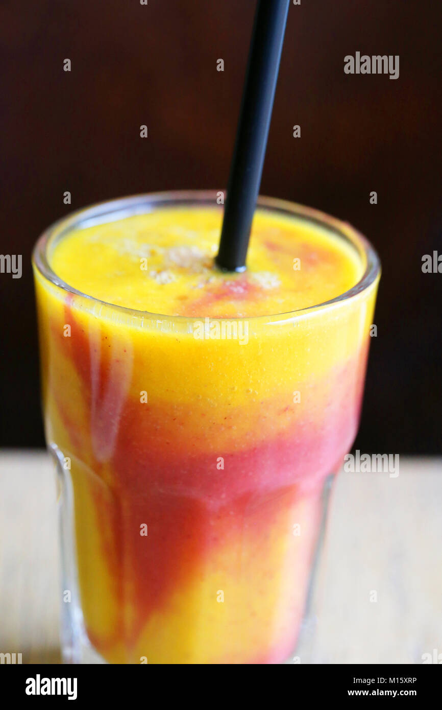 fruit juice in a glass with a straw Stock Photo - Alamy