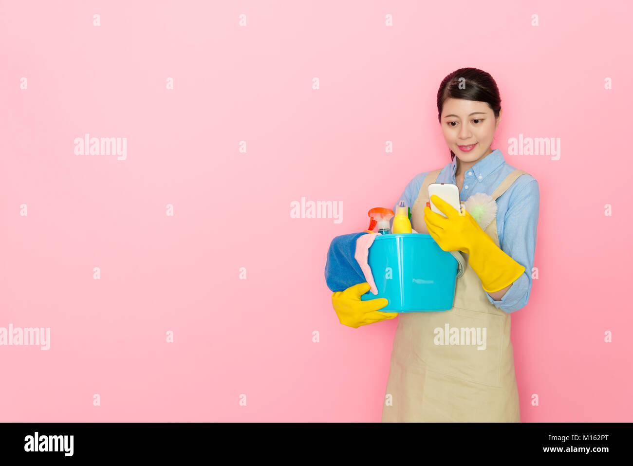 smiling pretty woman houseworker using mobile smartphone searching ...