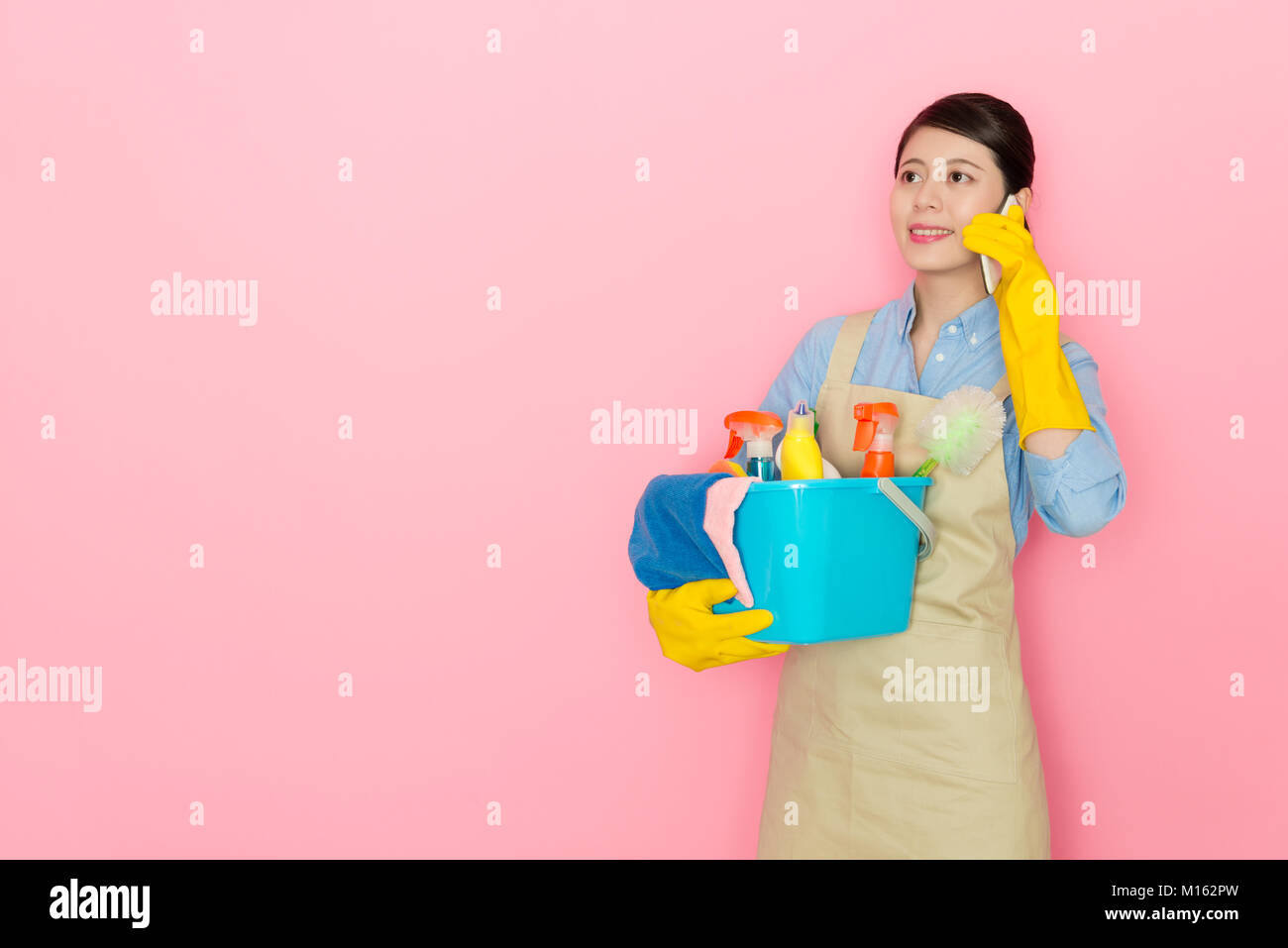 happy beautiful lady housekeeper finished housework standing in pink ...