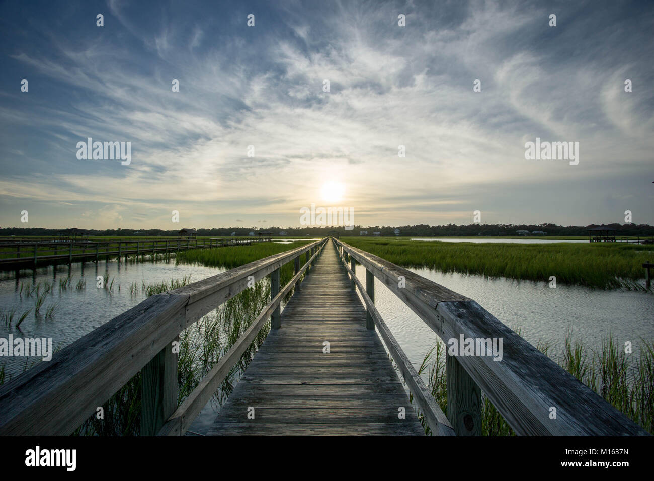 long wooden boardwalk pier over marsh at high tide with a fantastic ...