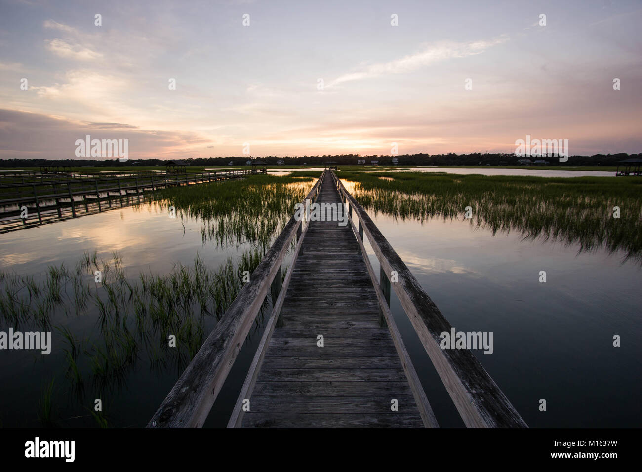 long wooden boardwalk pier over marsh at high tide with a fantastic ...