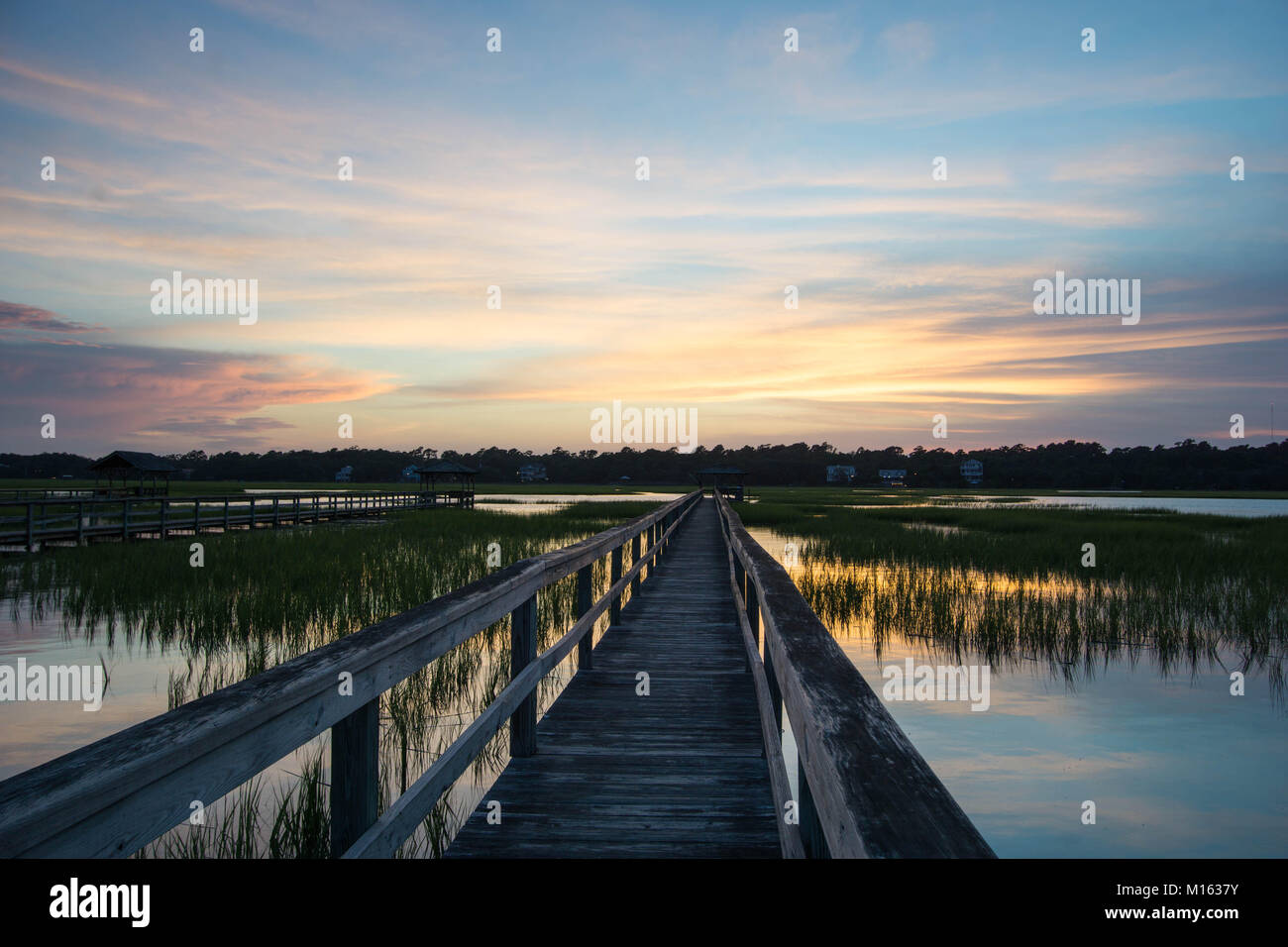 long wooden boardwalk pier over marsh at high tide with a fantastic ...