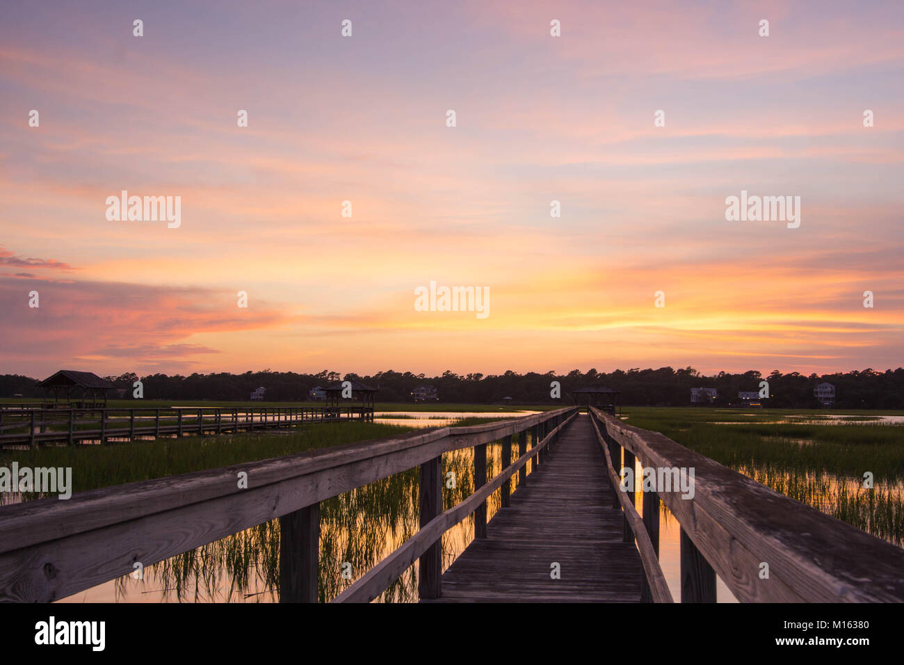long wooden boardwalk pier over marsh at high tide with a fantastic ...