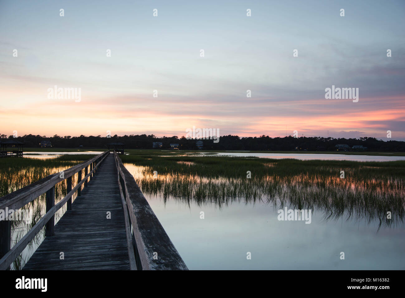 long wooden boardwalk pier over marsh at high tide with a fantastic ...