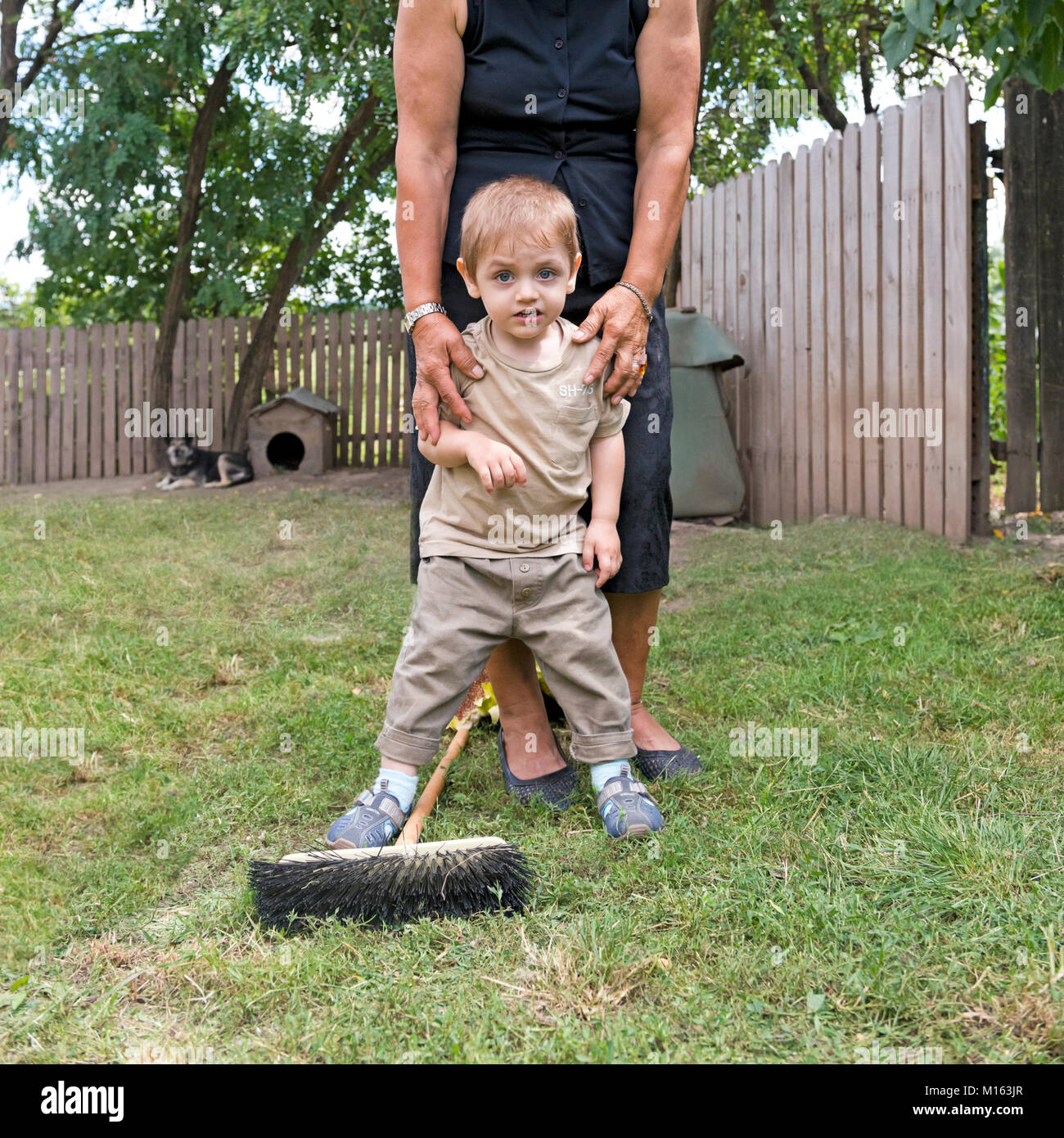 Blonde child with blue eyes, playing with a broom, outdoor, portraits ...