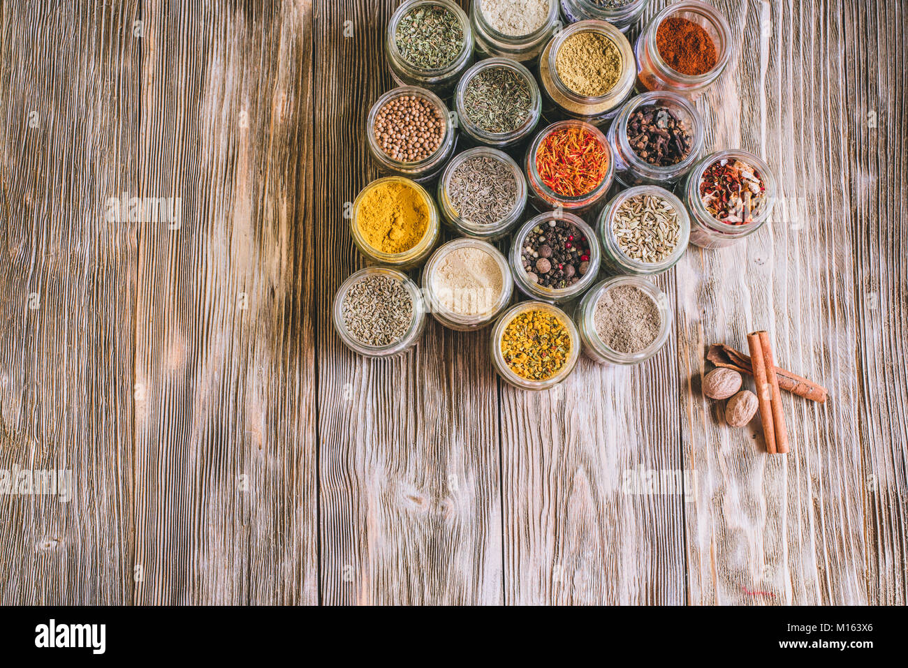 Various colorful kinds of spices on rustic wooden table, top view Stock ...