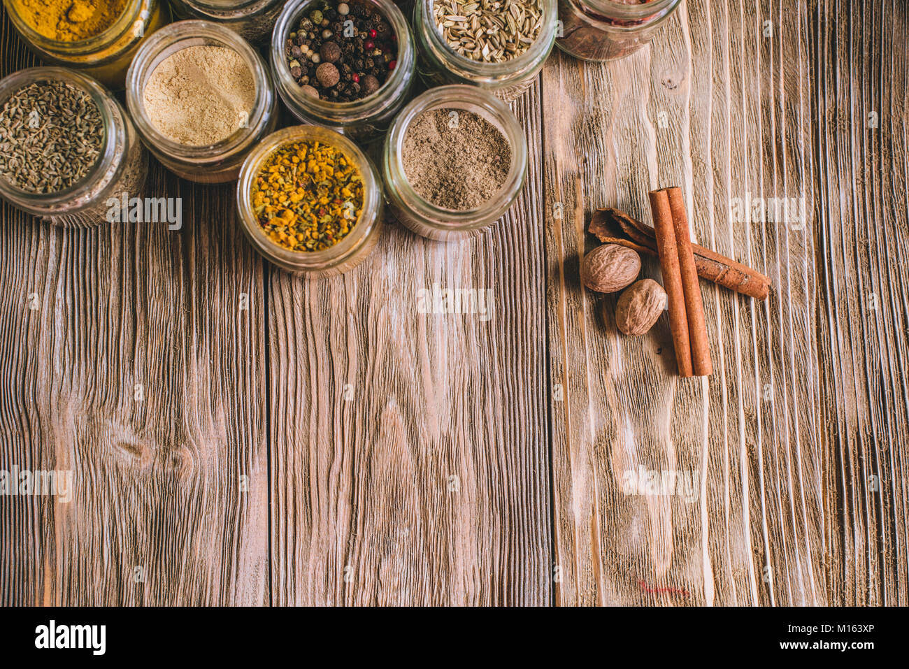 Various colorful kinds of spices on rustic wooden table, top view Stock ...