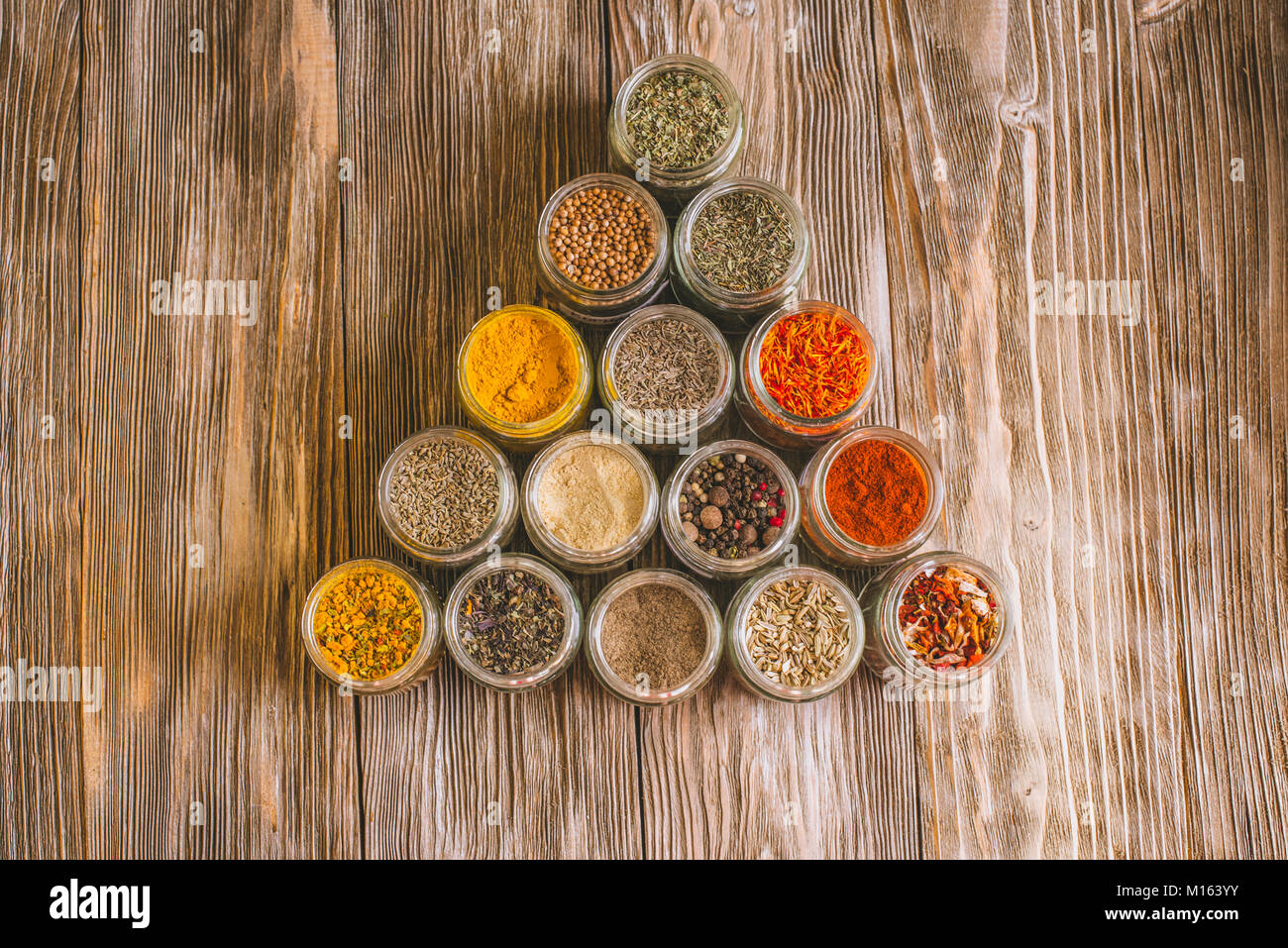 Various colorful kinds of spices on rustic wooden table, top view Stock ...