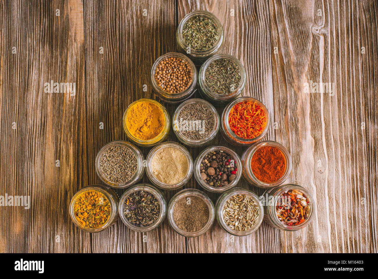 Various colorful kinds of spices on rustic wooden table, top view Stock ...