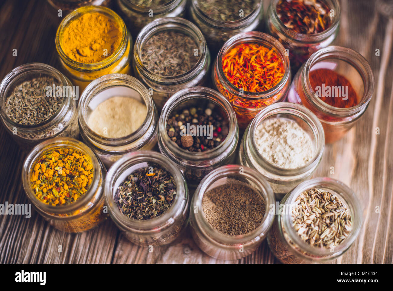 Various colorful kinds of spices on rustic wooden table, top view Stock ...