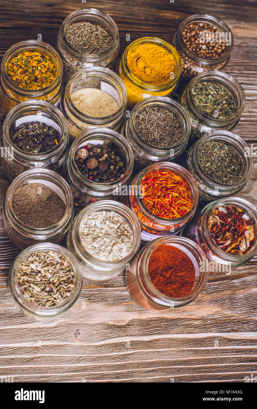 Various colorful kinds of spices on rustic wooden table, top view Stock ...