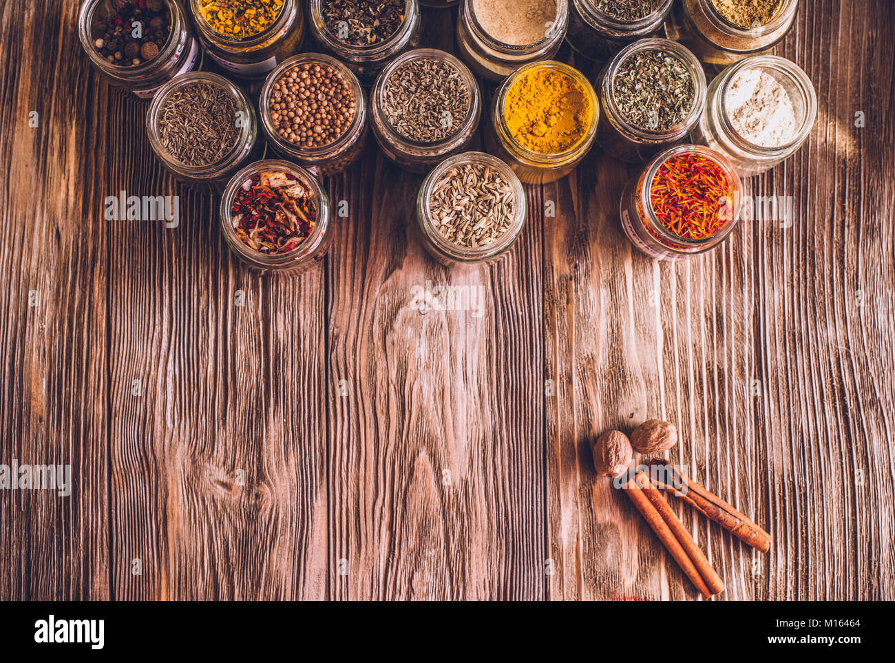 Various colorful kinds of spices on rustic wooden table, top view Stock ...