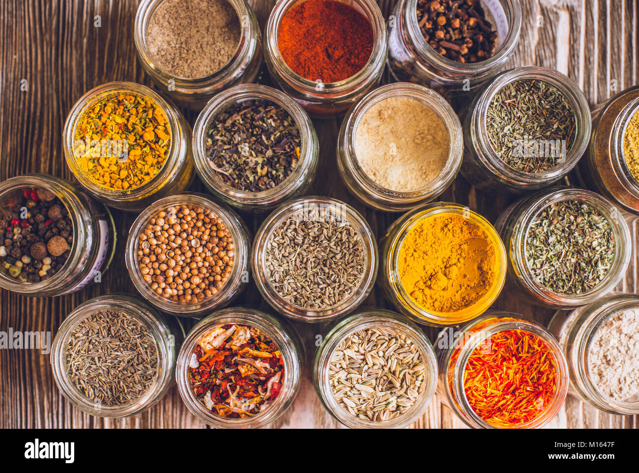 Various colorful kinds of spices on rustic wooden table, top view Stock ...