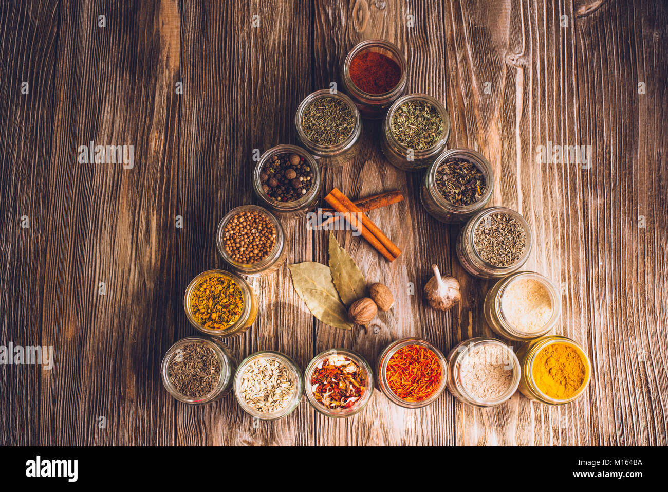 Various colorful kinds of spices on rustic wooden table, top view Stock ...
