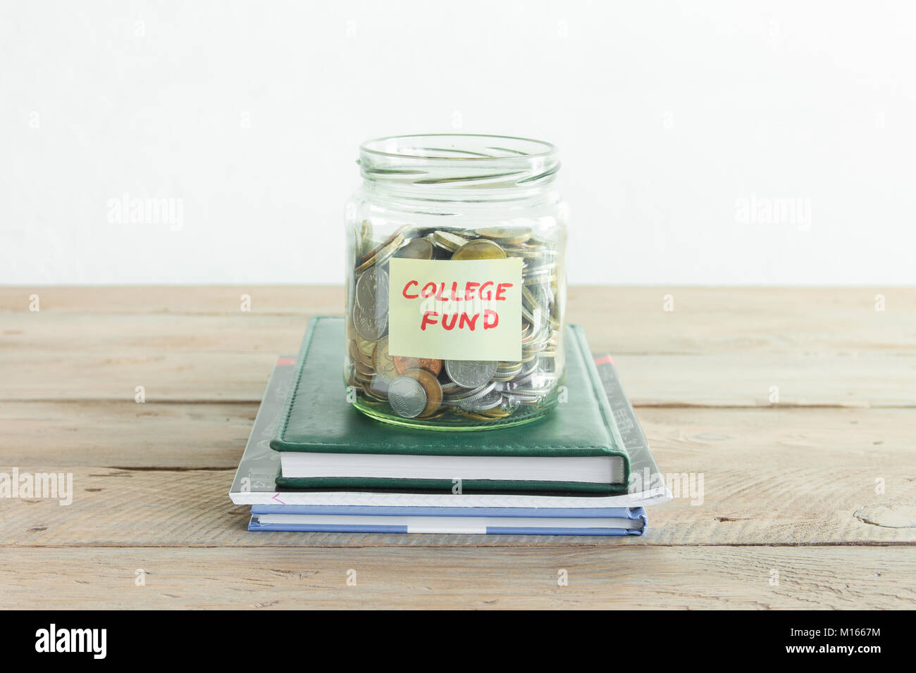 Coins in glass jar with College Fund label and books. Money savings ...