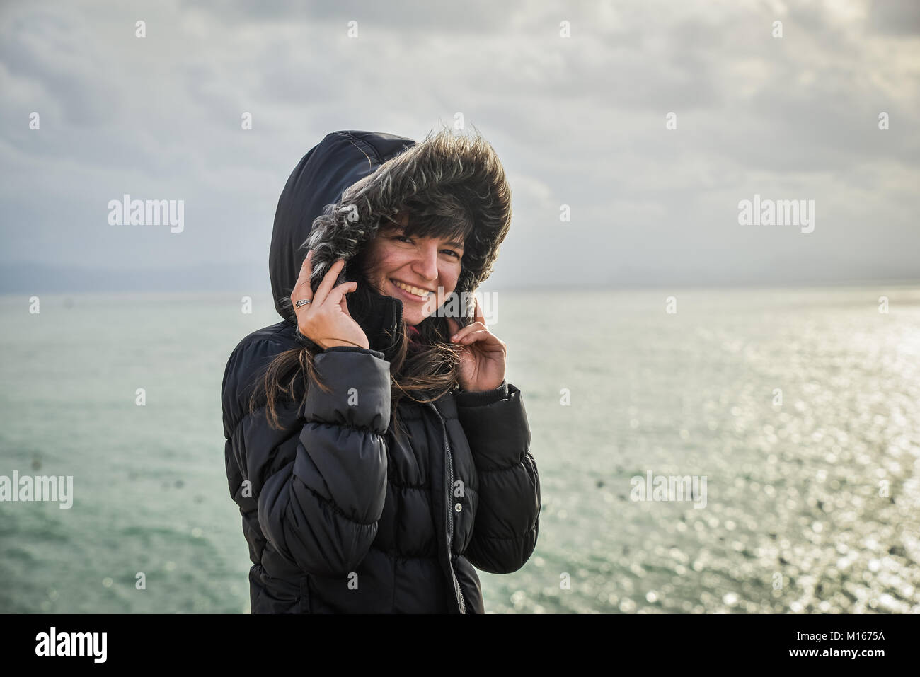 Girl in winter jacket by the sea Stock Photo - Alamy