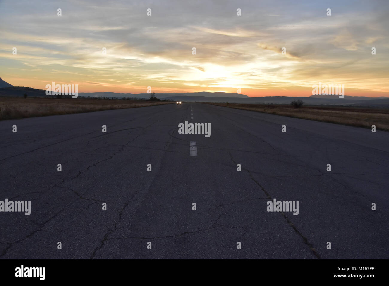 Reaching the horizon wide straight asphalt road after sunset ...