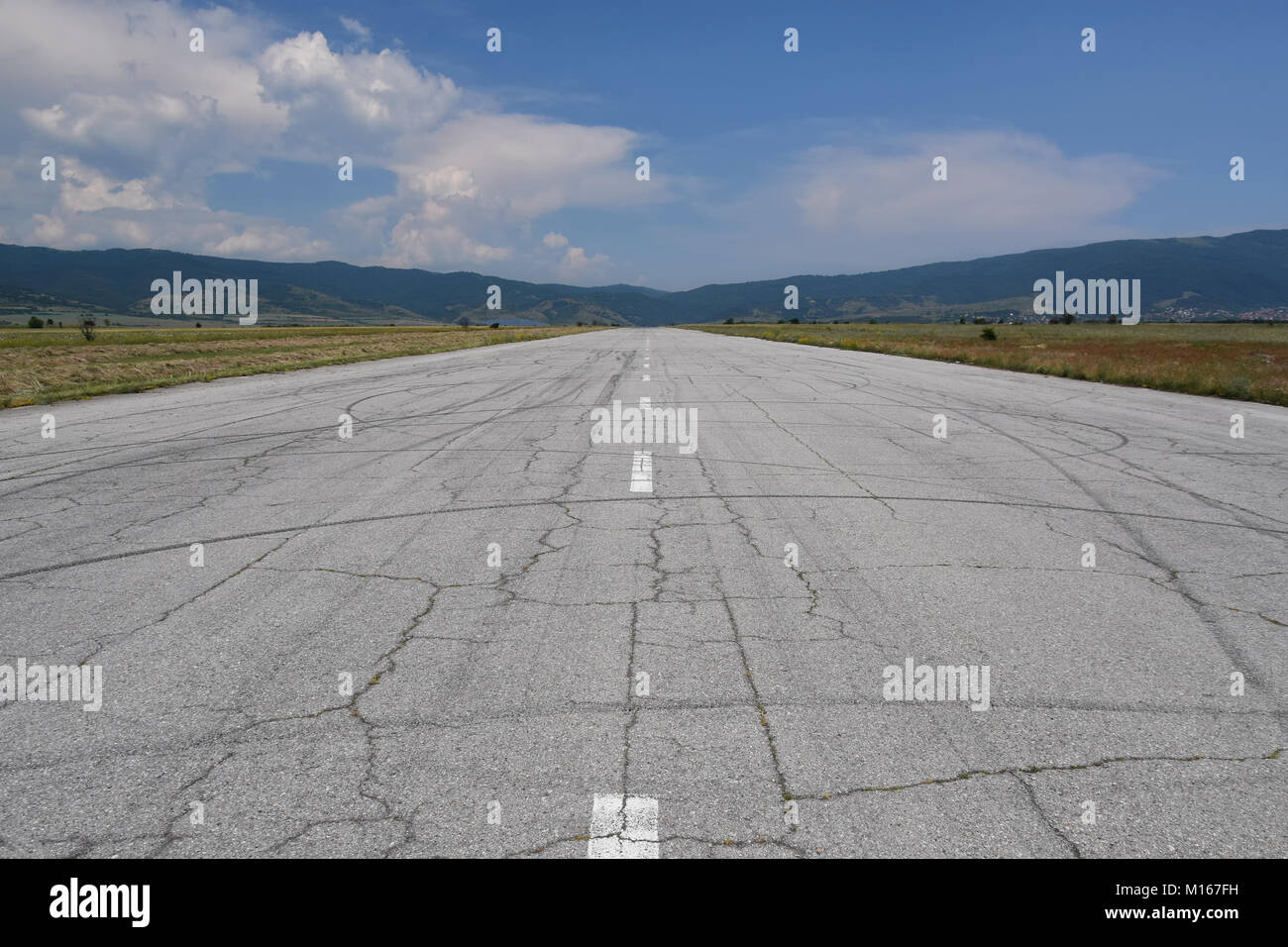 Abandoned runway used as rally racetrack. Hot summer day. Cracks and ...