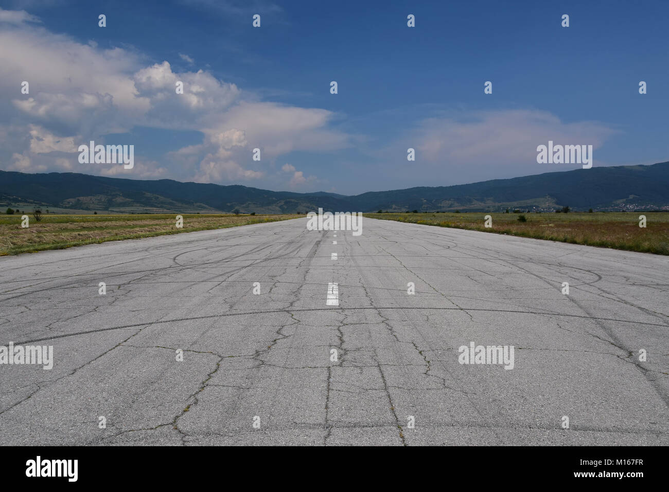 Abandoned runway used as rally racetrack. Hot summer day. Cracks and ...