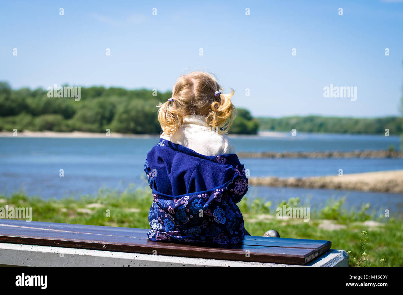 rear view of blond girl sitting in bench Stock Photo - Alamy