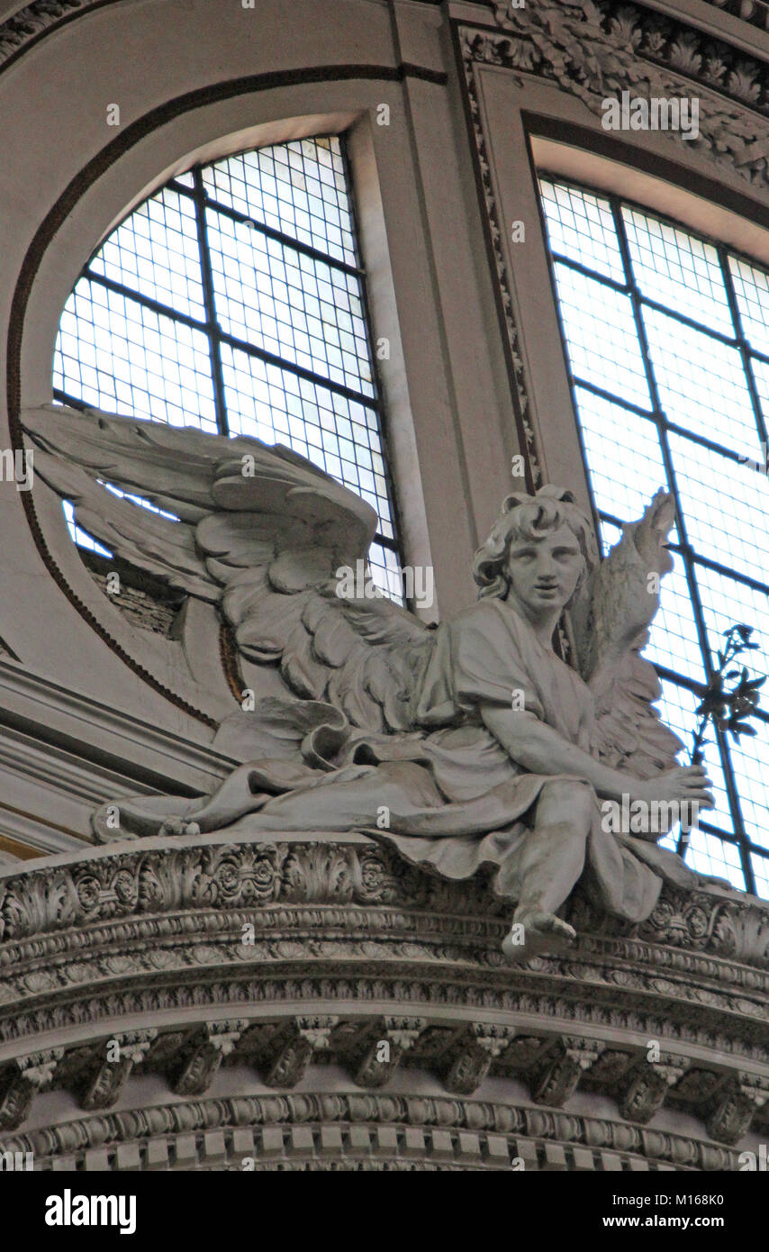 Statue of angel sitting on a balcony with flowers at the Basilica di ...