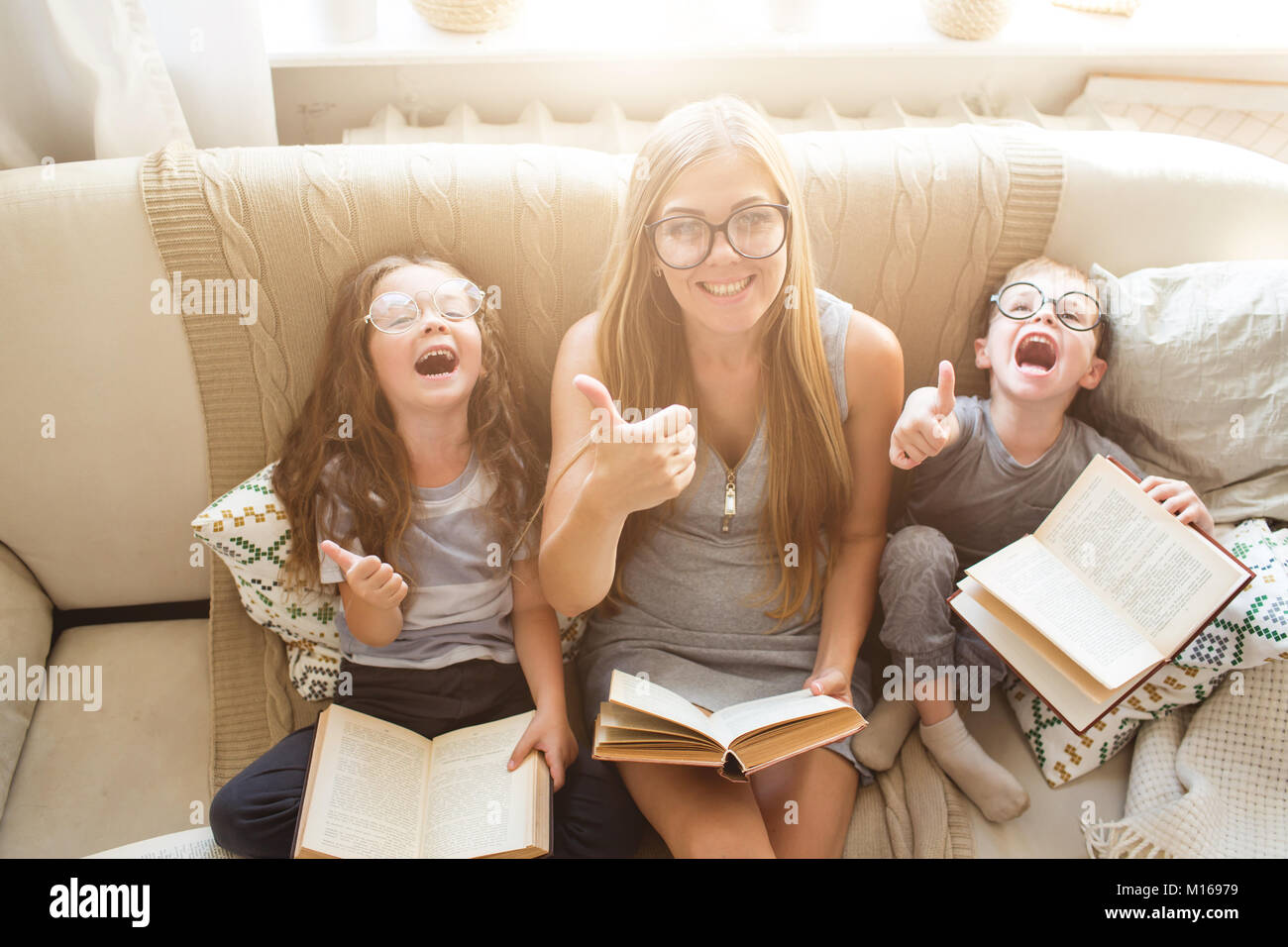 Happy family learning together. Children with books Stock Photo - Alamy