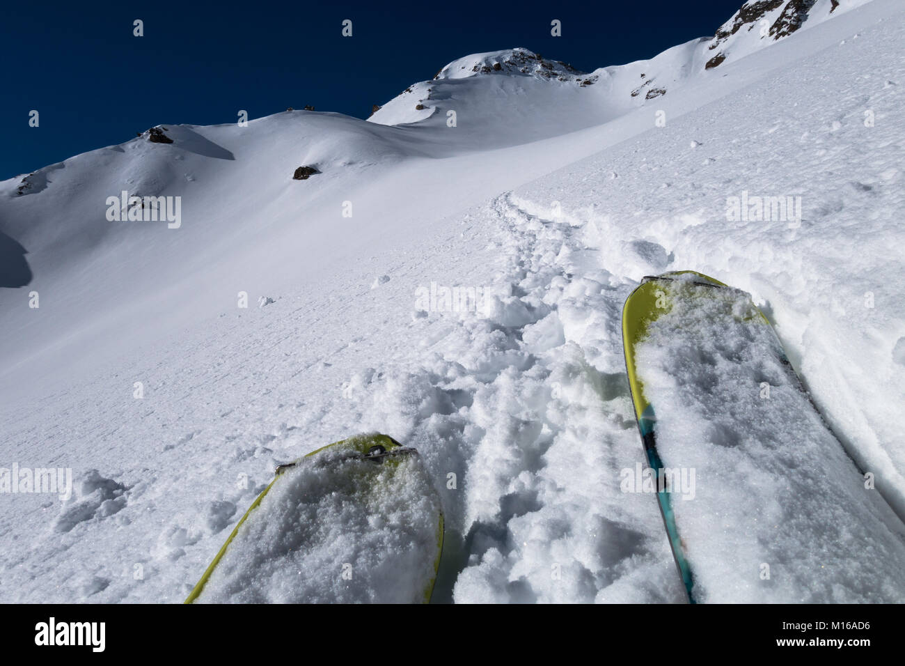 A skier following touring track leading up to alpine mountain pass in ...
