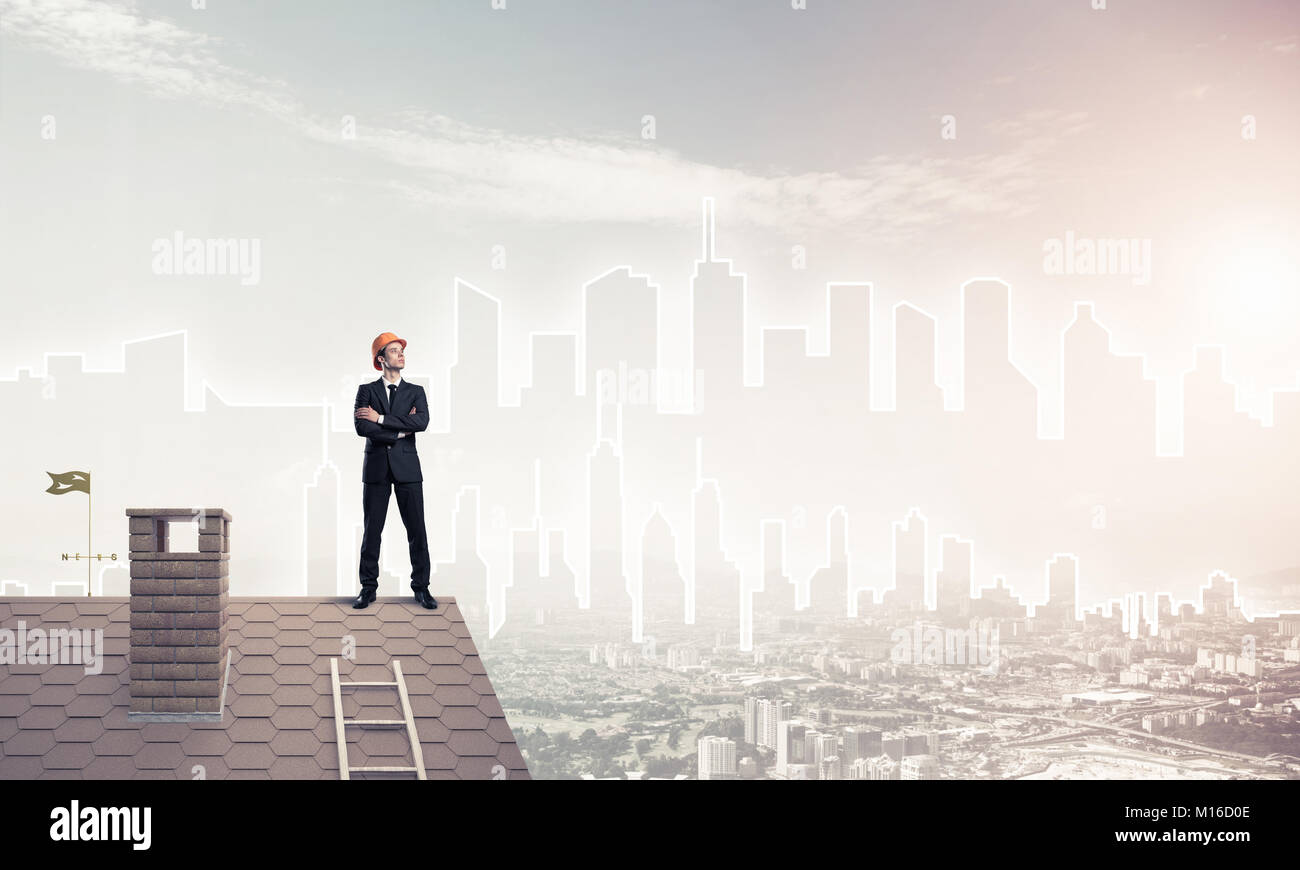 Engineer man standing on roof and looking away. Mixed media Stock Photo ...