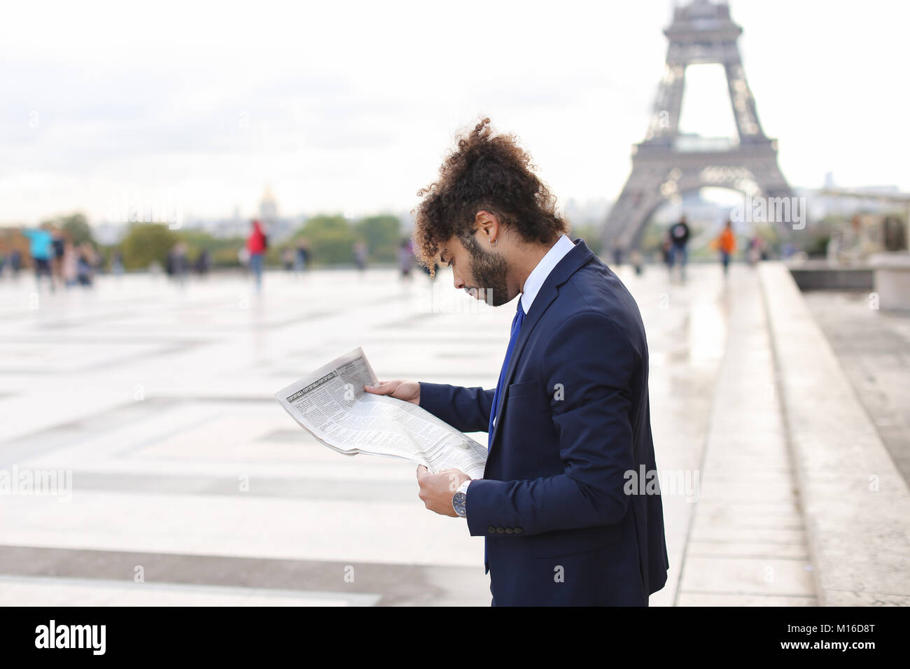 pressman reading newspaper article near Eiffel Tower Stock Photo - Alamy