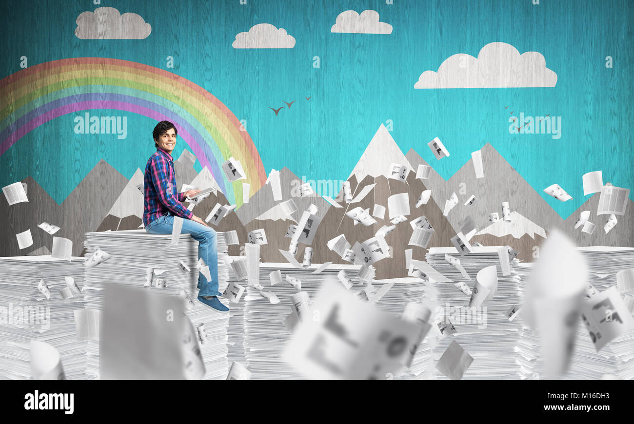 Young man sitting on pile of paper documents Stock Photo - Alamy