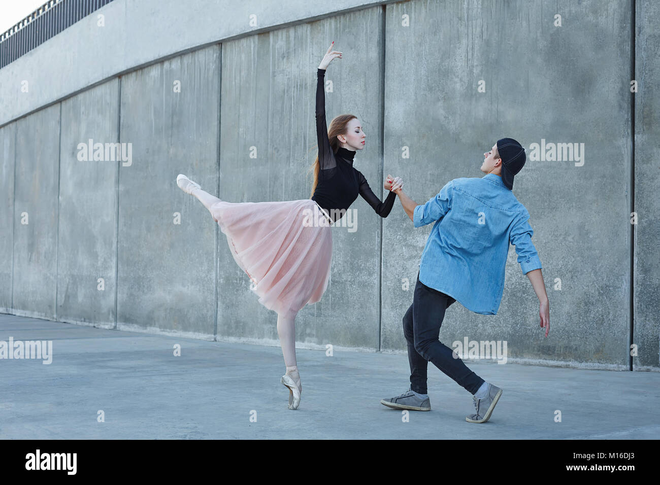 Slender ballerina dances with a modern dancer. Date of lovers ...