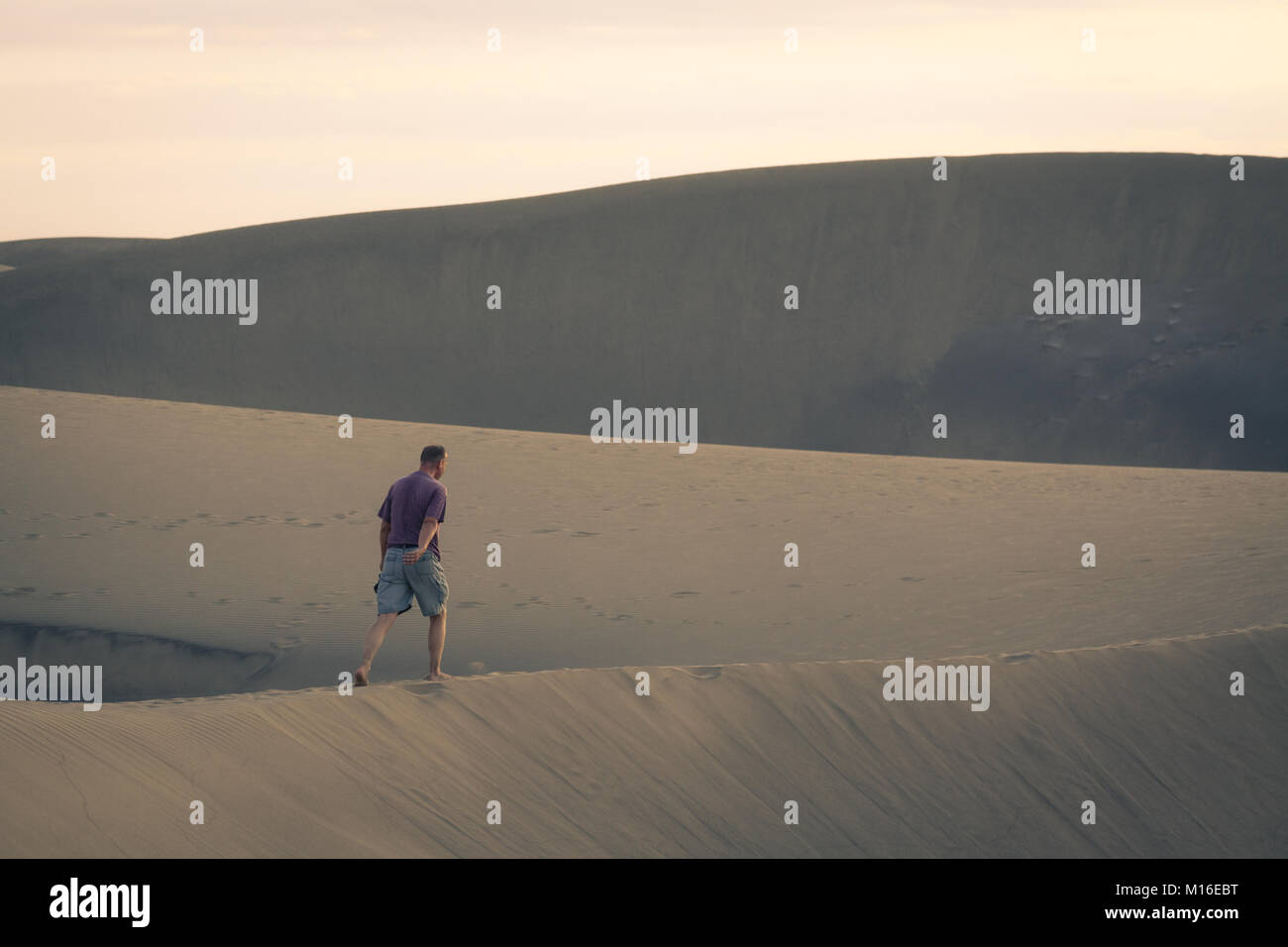 Young man walking sand dune sunset hi-res stock photography and images ...