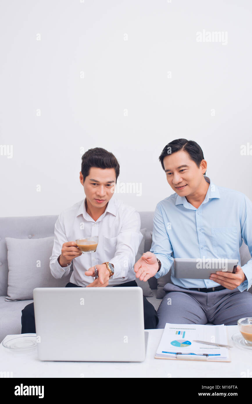 Two confident young businesspeople using a laptop discuss information ...