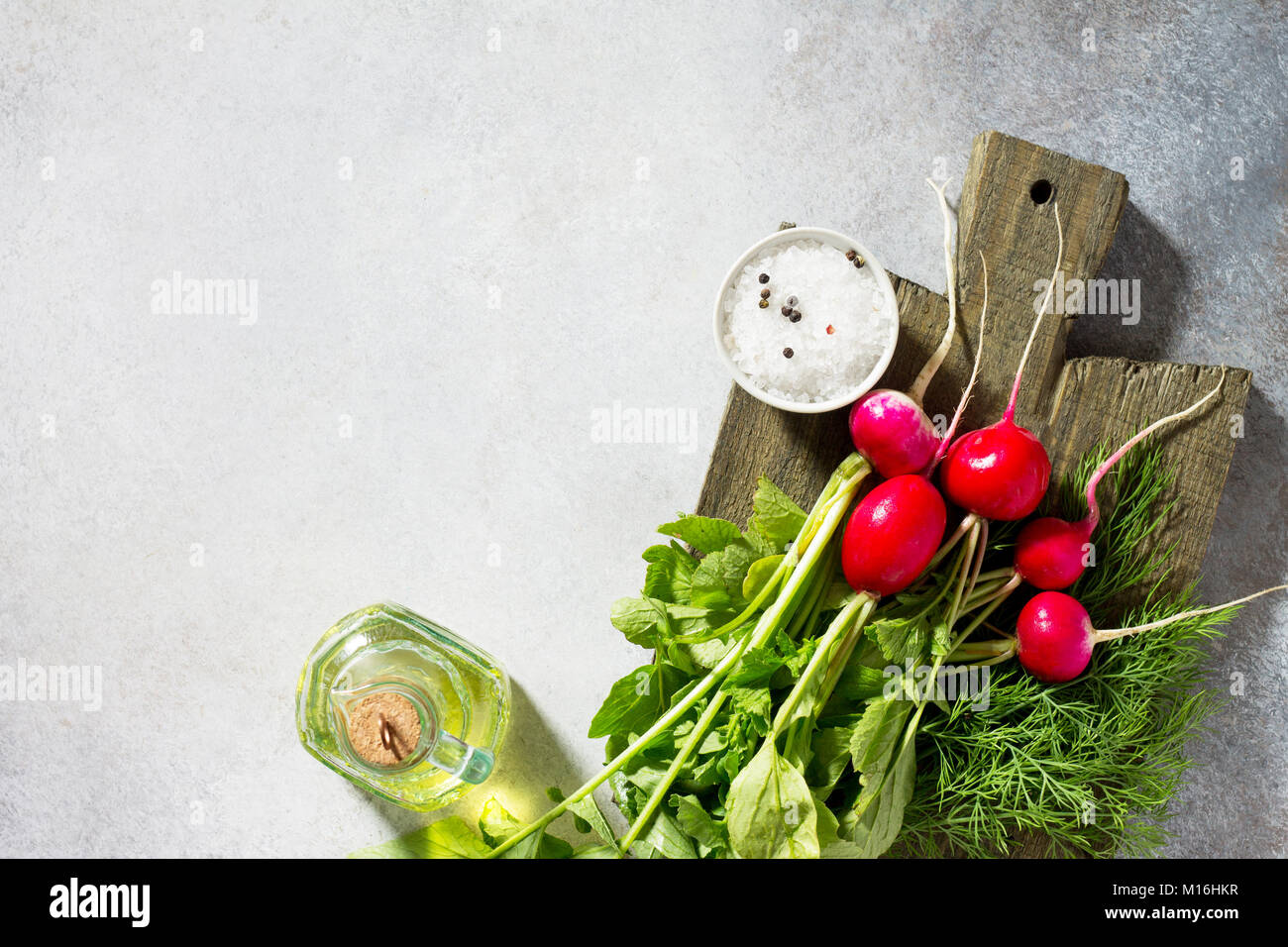 Radish. Red fresh radish, olive oil and fresh herbs on a stone or slate ...