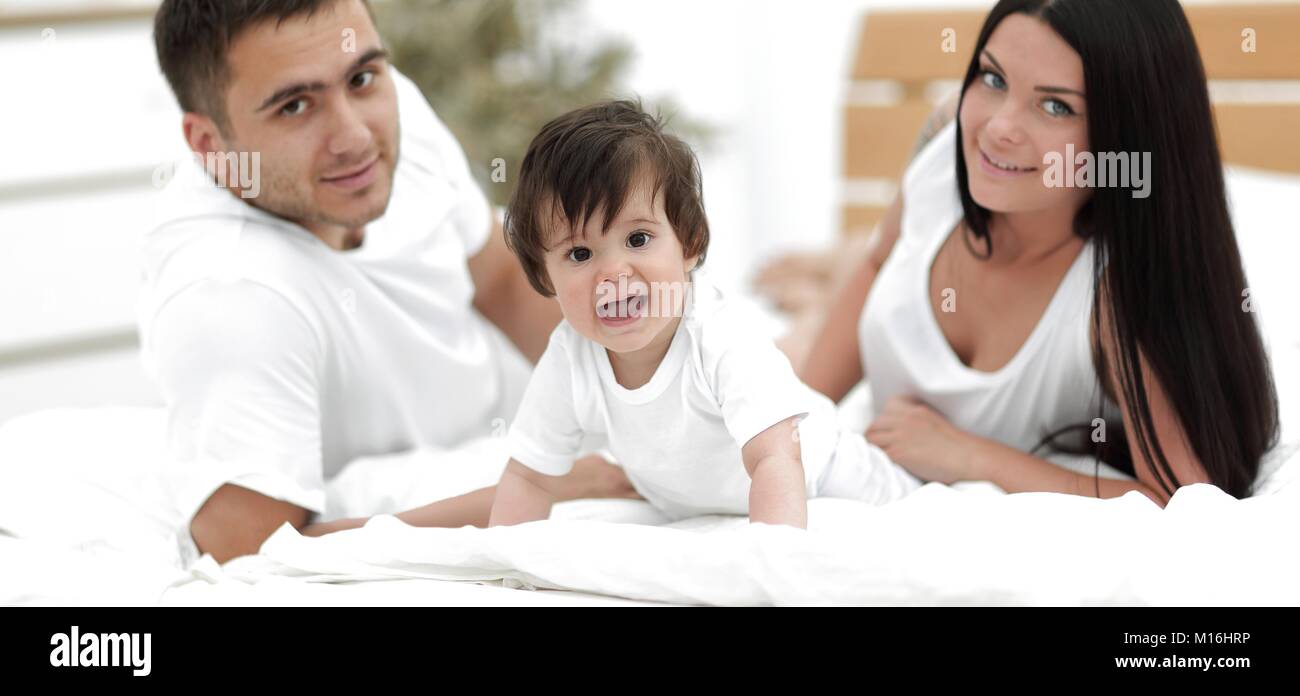 Portrait of parents and son lying on bed in bedroom at home Stock Photo ...