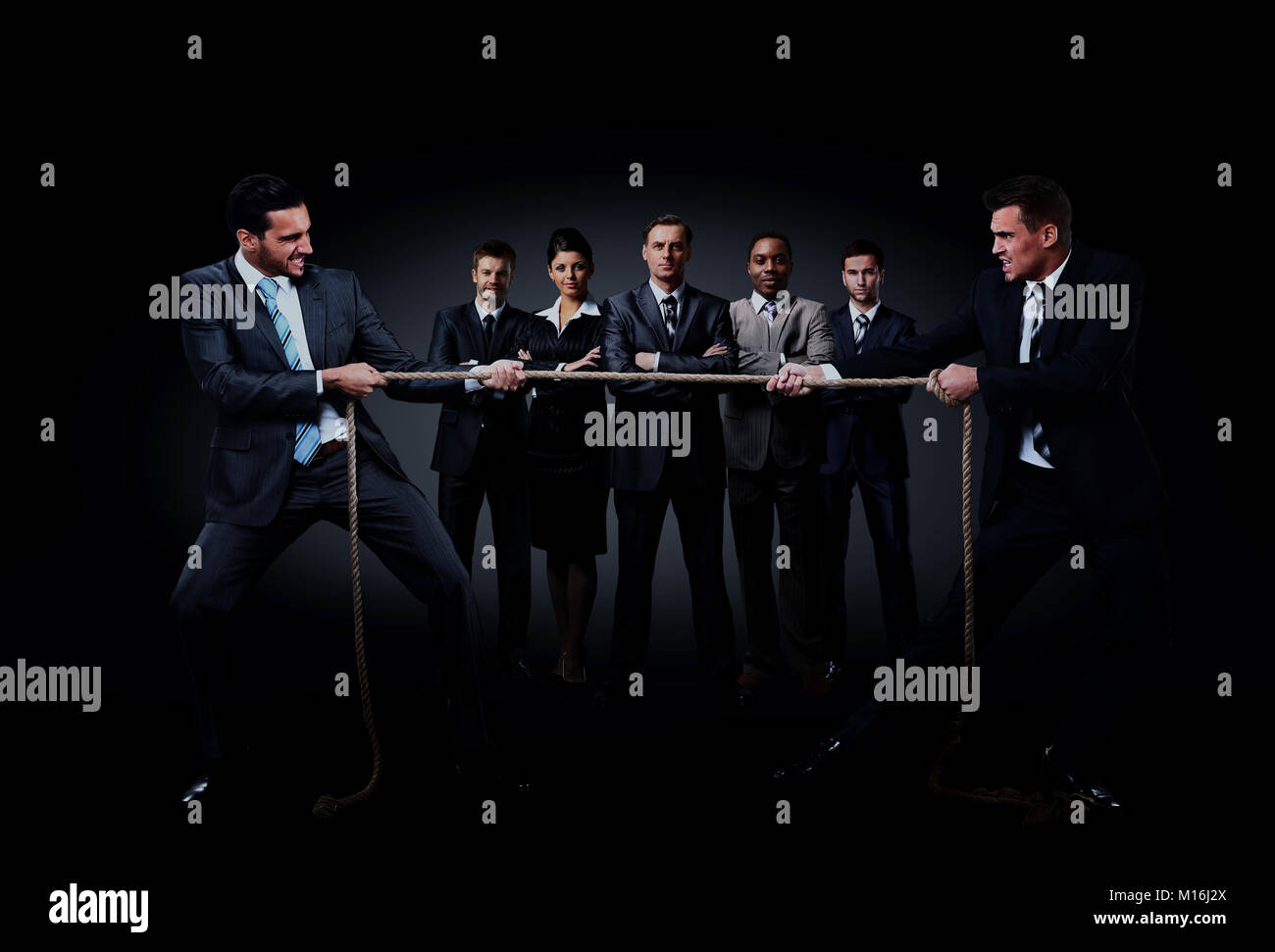 Two business men pulling rope in a competition. in the background is a ...