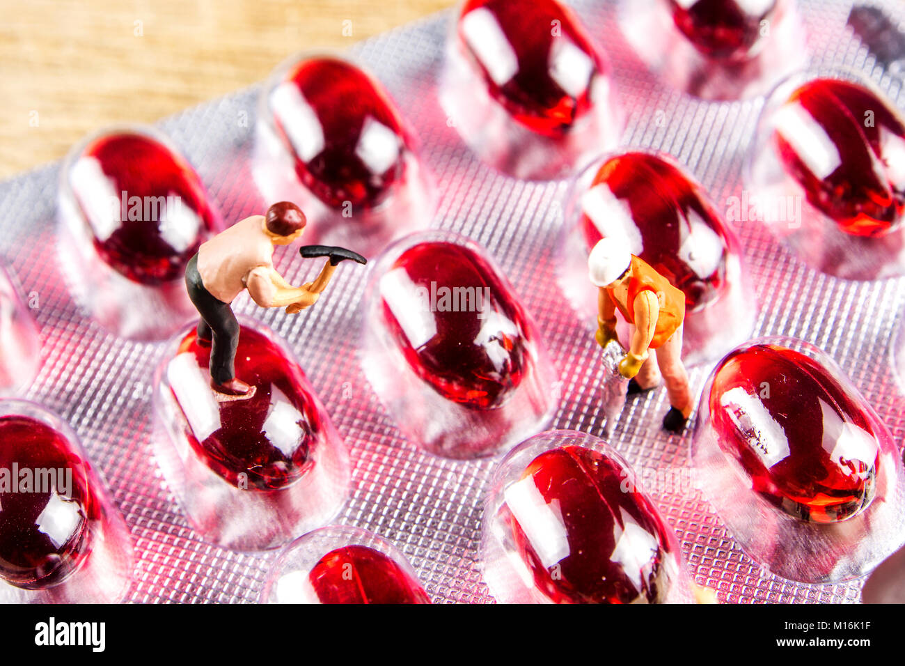 miniature figurines working hard together in order to make medicine ...