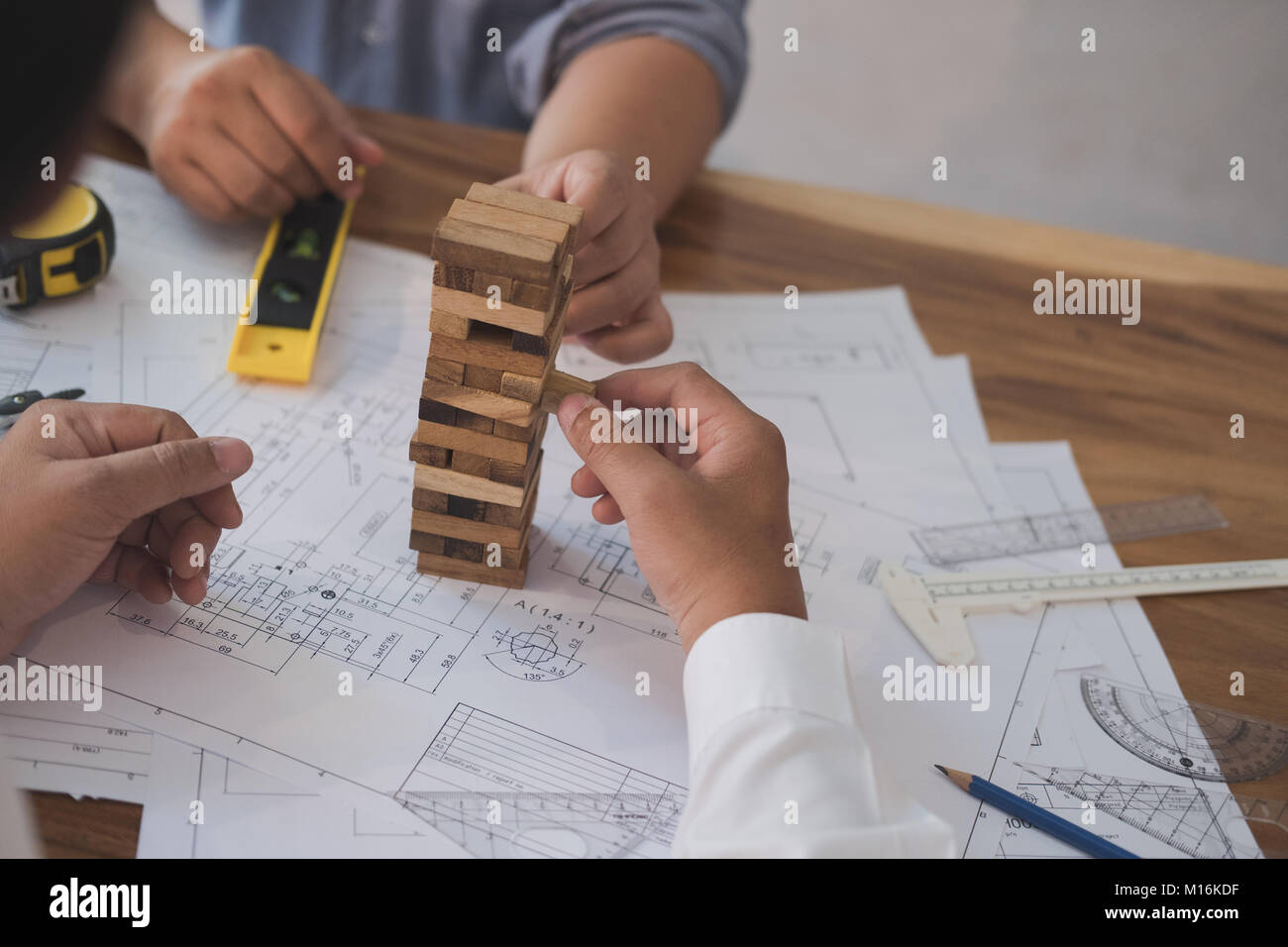 engineer & architect playing wood block games on blueprint of ...