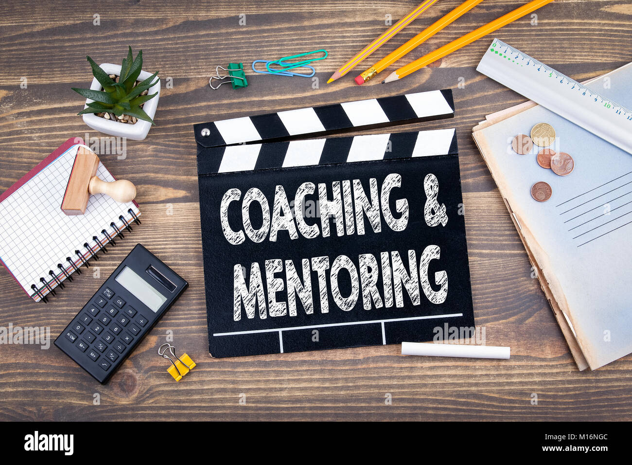 Coaching and Mentoring. movie clapper on a wooden desk Stock Photo - Alamy