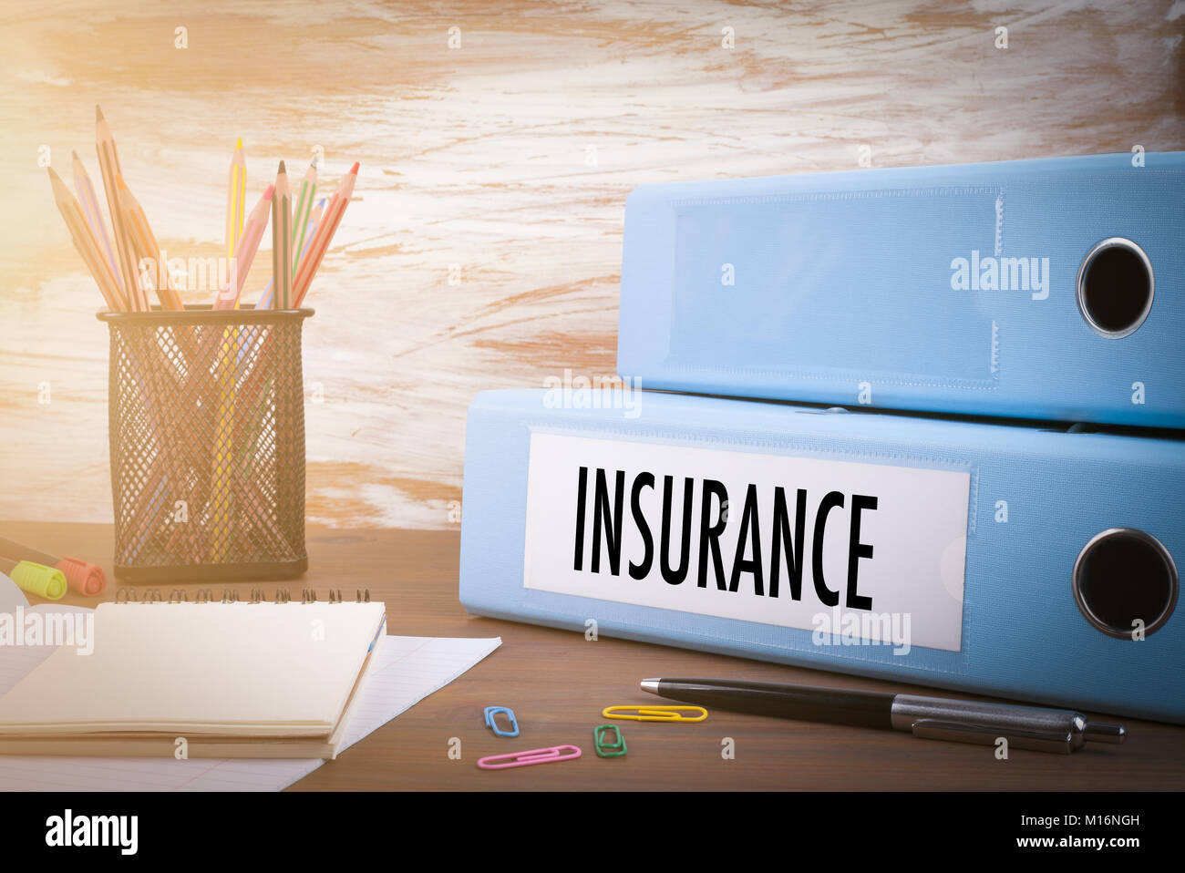 insurance, Office Binder on Wooden Desk. On the table colored pencils ...