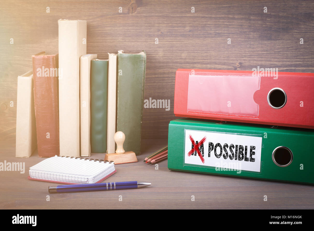 Change impossible to possible. Binder on desk in the office. Business ...