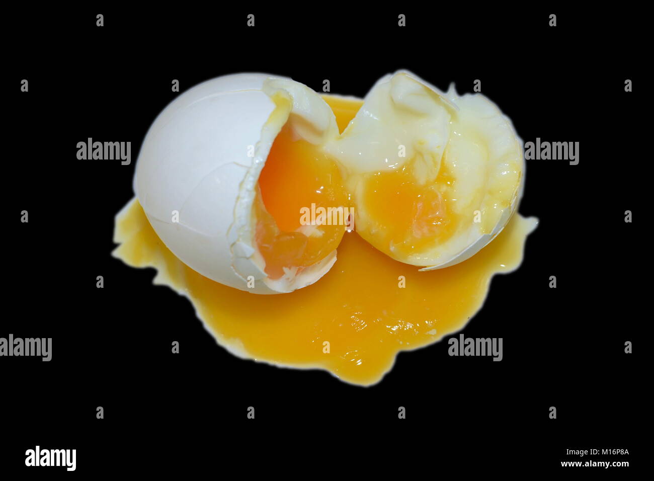 A opened boiled egg has leaked on a black background Stock Photo - Alamy