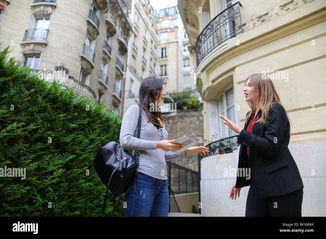 Jocund girl paying Chinese teacher with card and tablet for less Stock ...