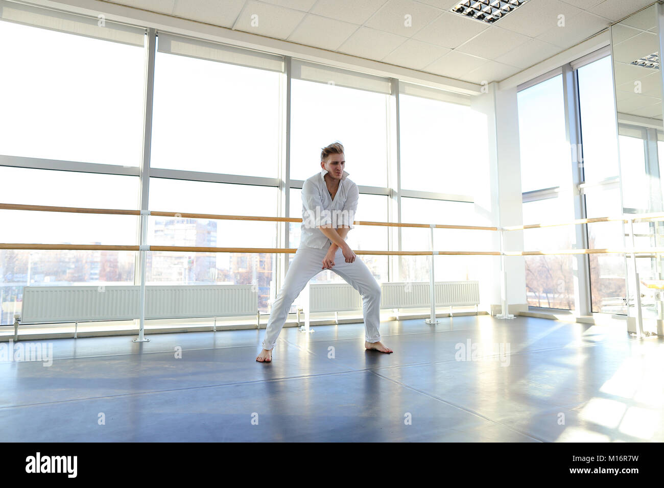 Young blonde dancer enjoys winning in white suit and makes warm Stock ...
