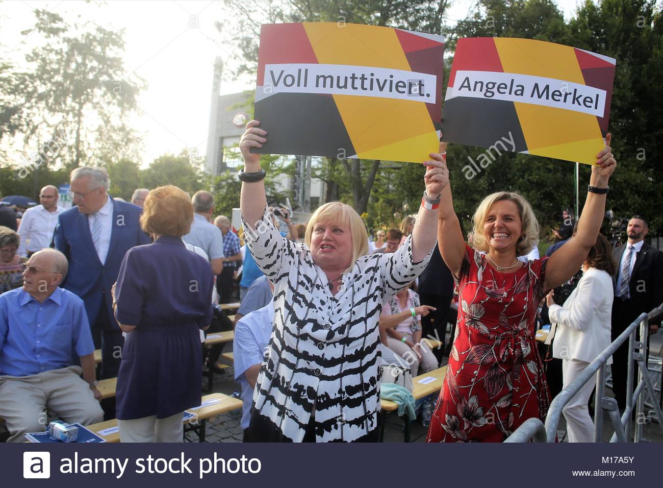 Two supporters of the CDU/CSU government parties hold proMerkel signs ...