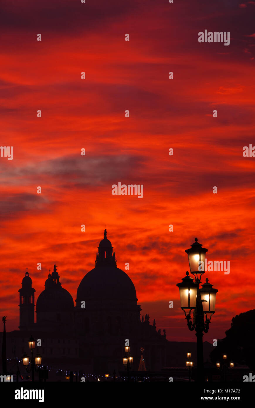 Red blood sky sunset over Venice Lagoon with Salute Basilica domes ...