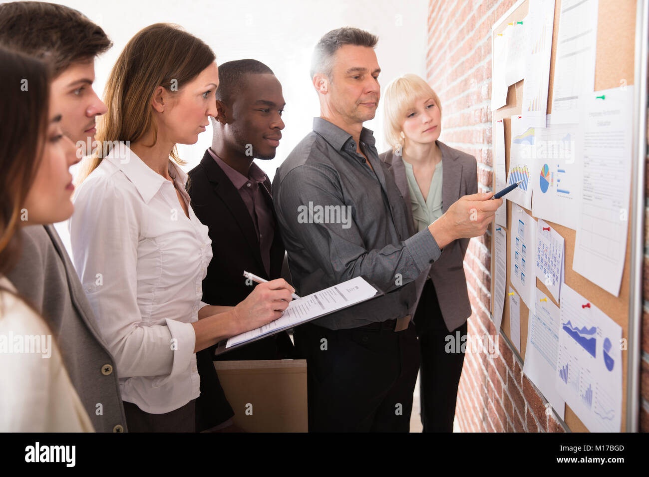 Mature Manager Analyzing The Graph With His Colleague Attached On ...